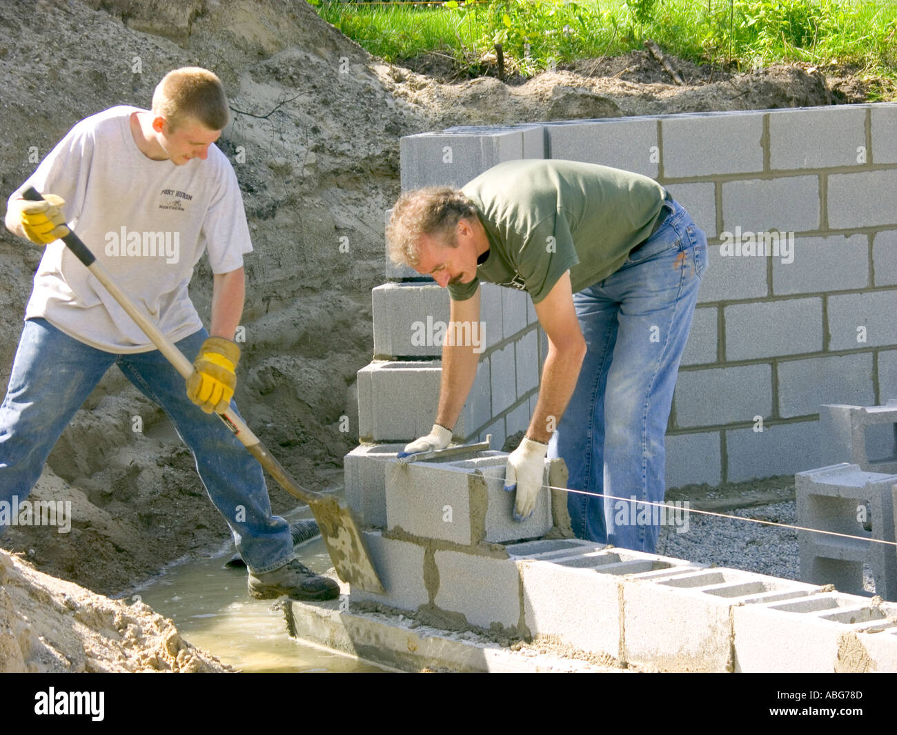 New home construction workers lay cement blocks to form basement of ...