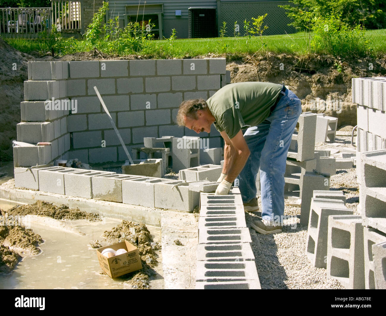 New home construction workers lay cement blocks to form basement of ...