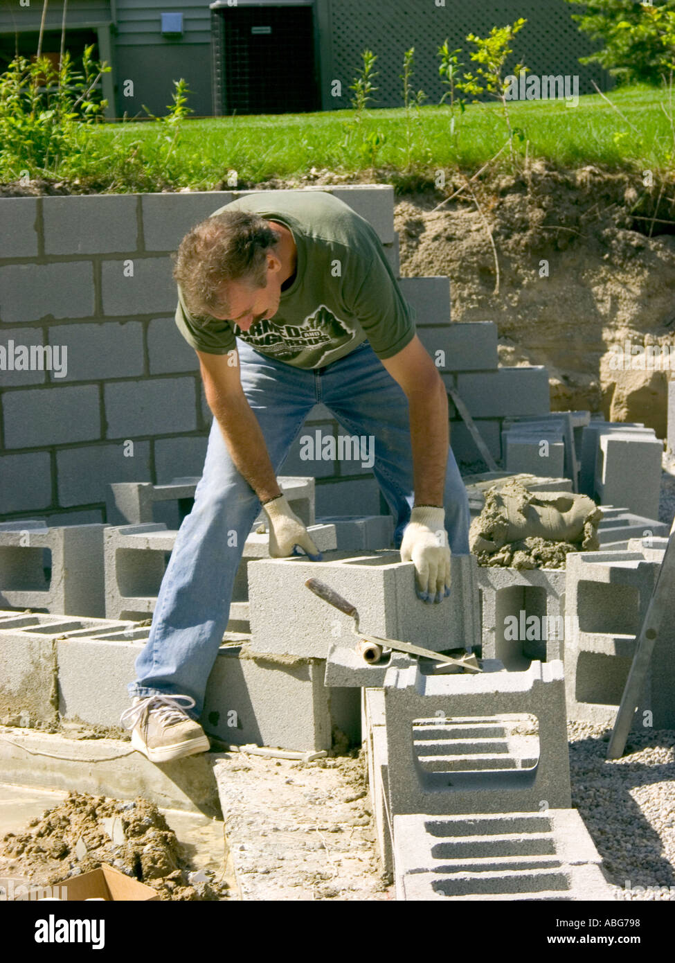 New home construction workers lay cement blocks to form basement of ...