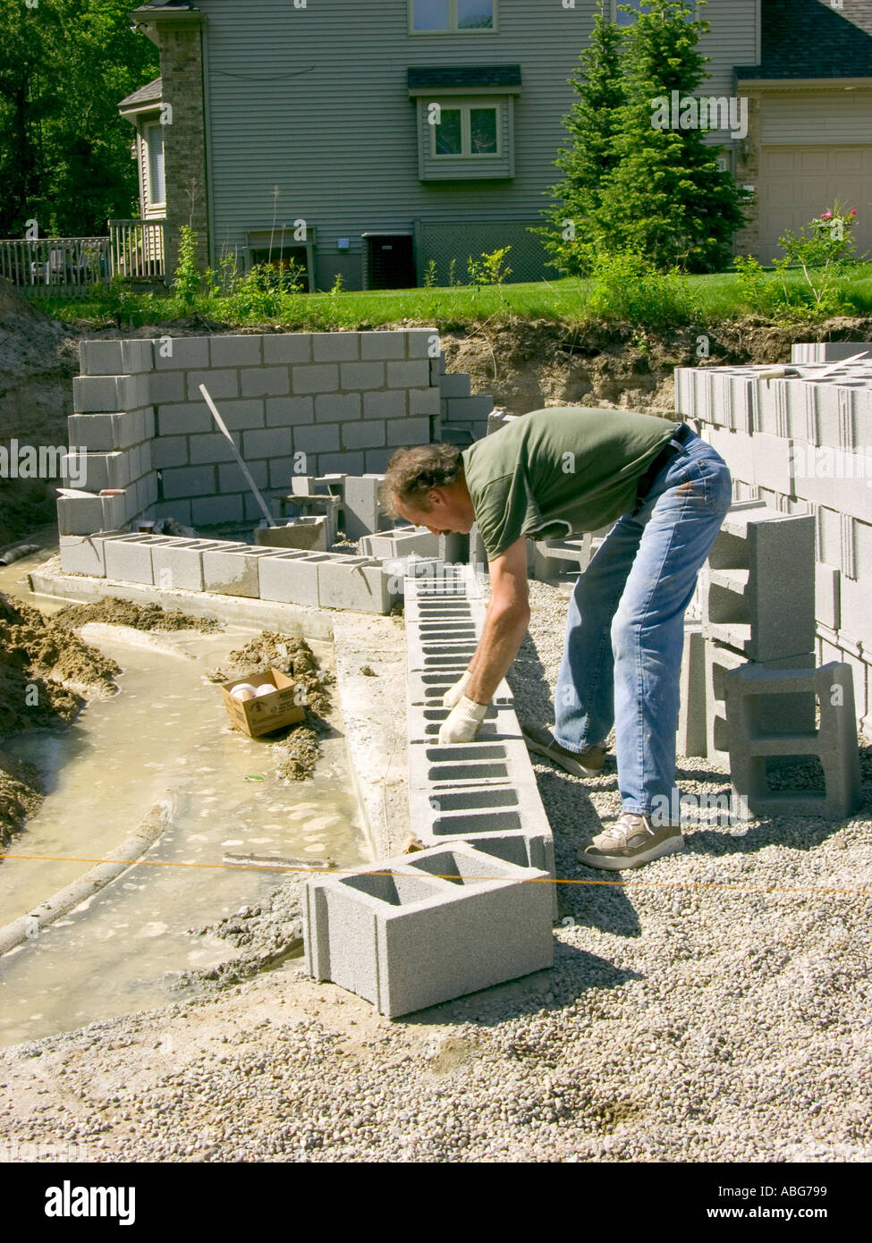 New home construction workers lay cement blocks to form basement of ...