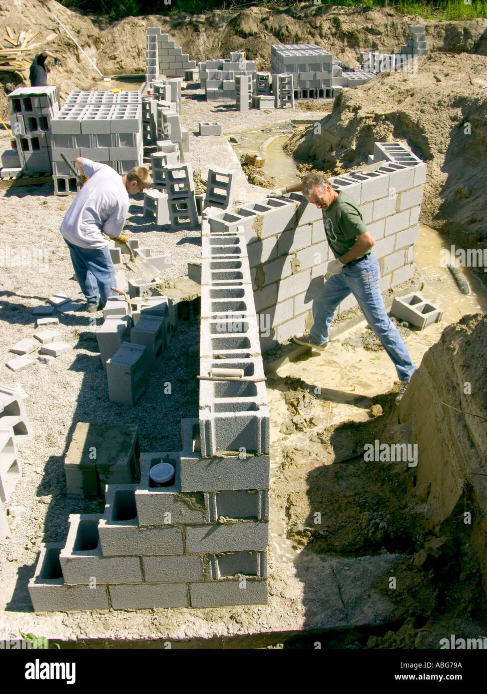 New home construction workers lay cement blocks to form basement of ...