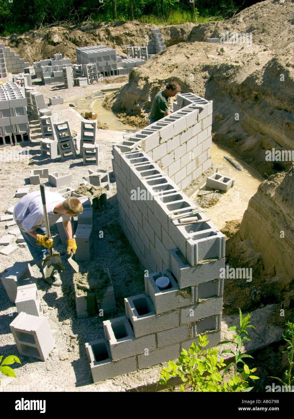 New home construction workers lay cement blocks to form basement of ...