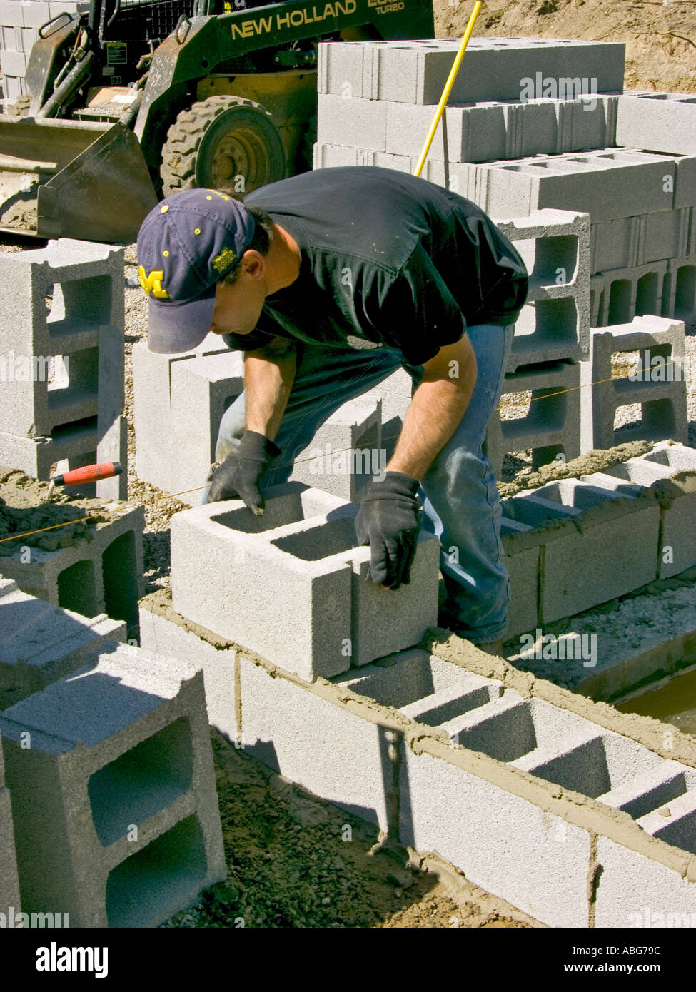 New home construction workers lay cement blocks to form basement of ...