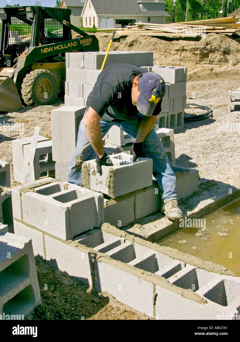 New home construction workers lay cement blocks to form basement of ...
