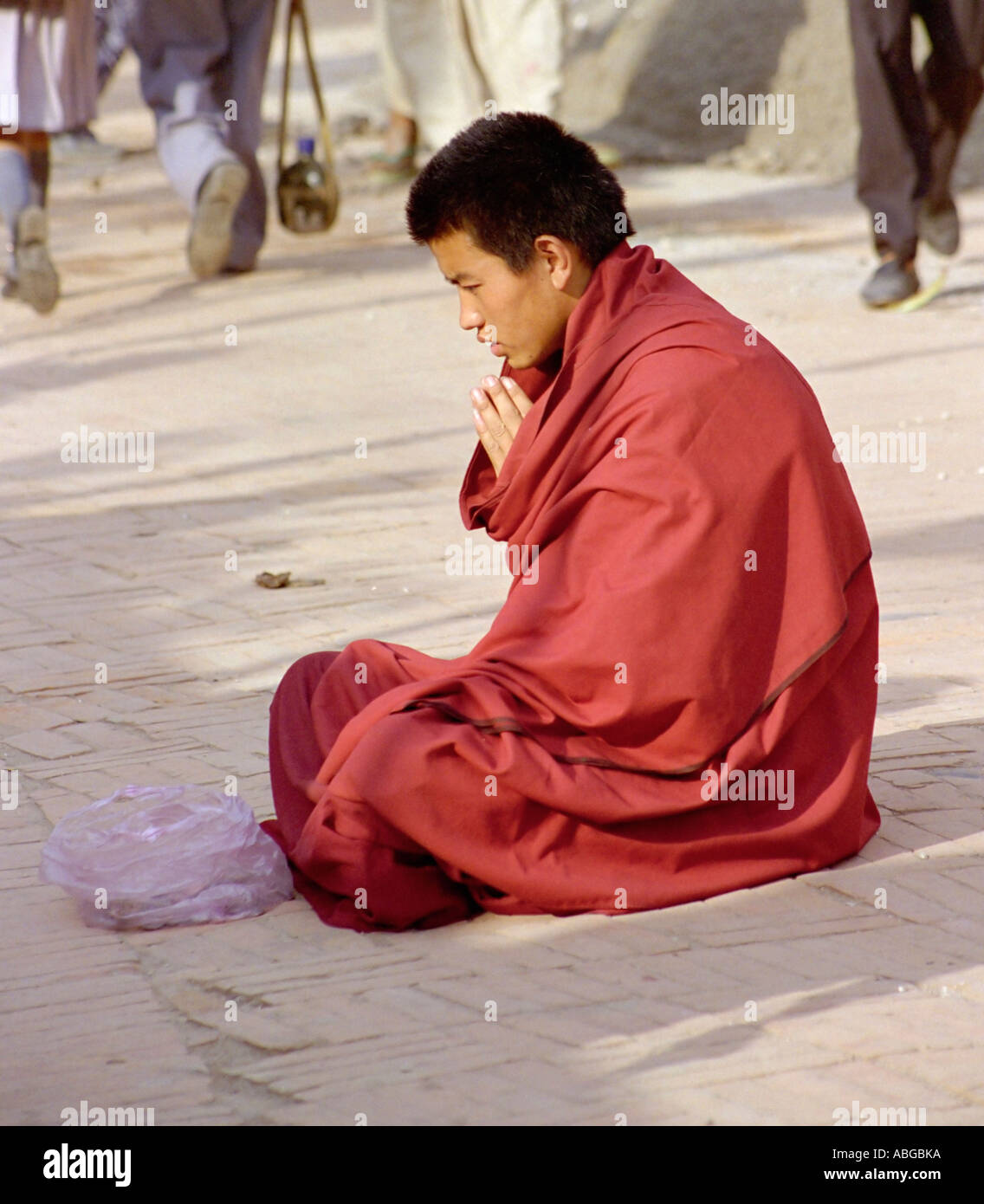 Monk seated in prayer at the stupa of Bouddhanath near Kathmandu Nepal ...