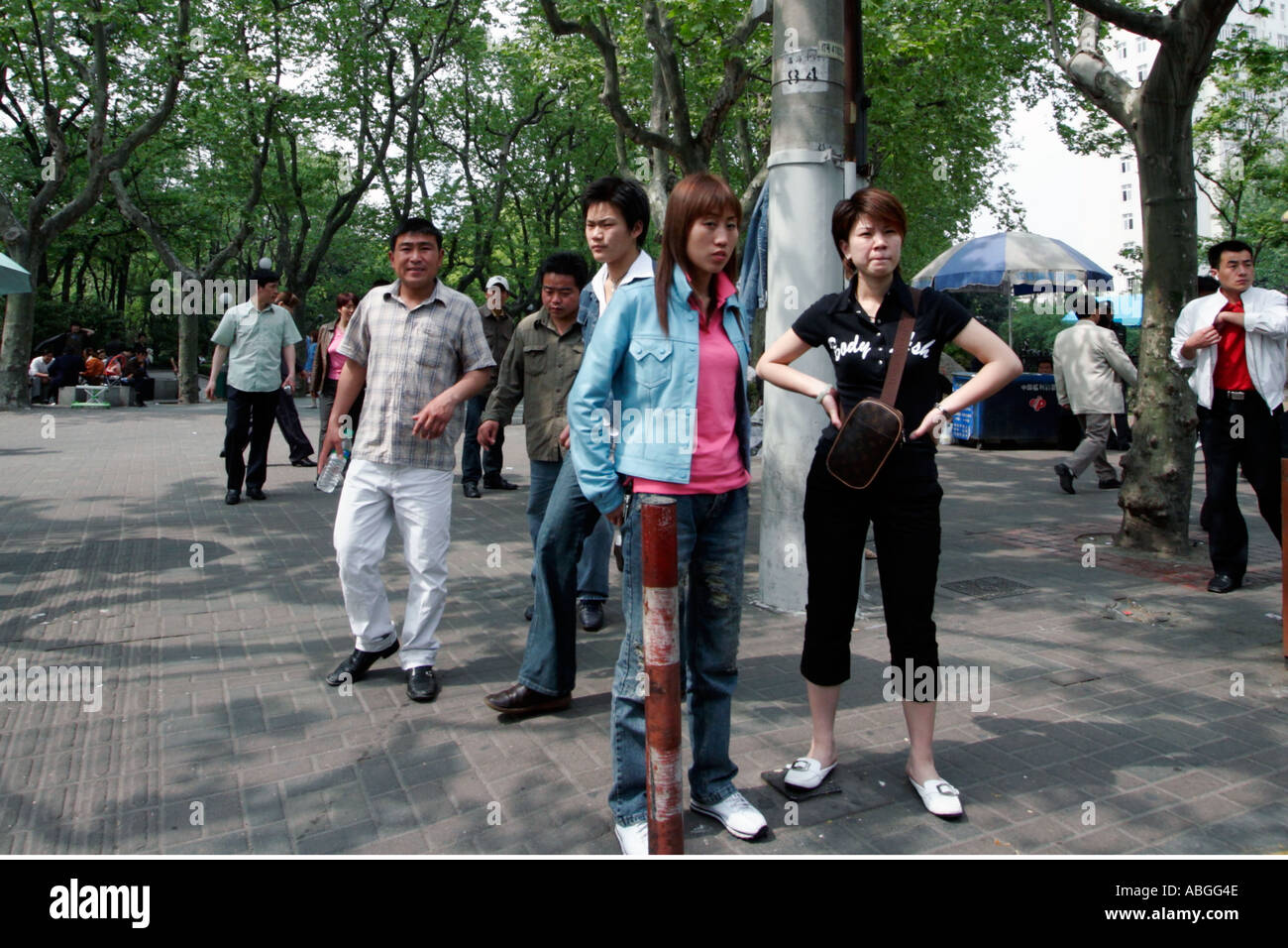 Two modern and fashionable Chinese women wait at a traffic corner in ...