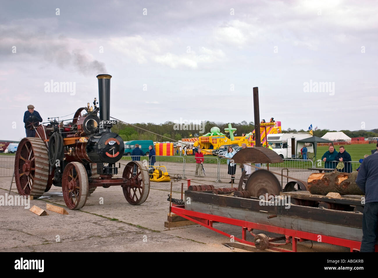 Vintage steam traction engine connected to industrial circular wood saw ...