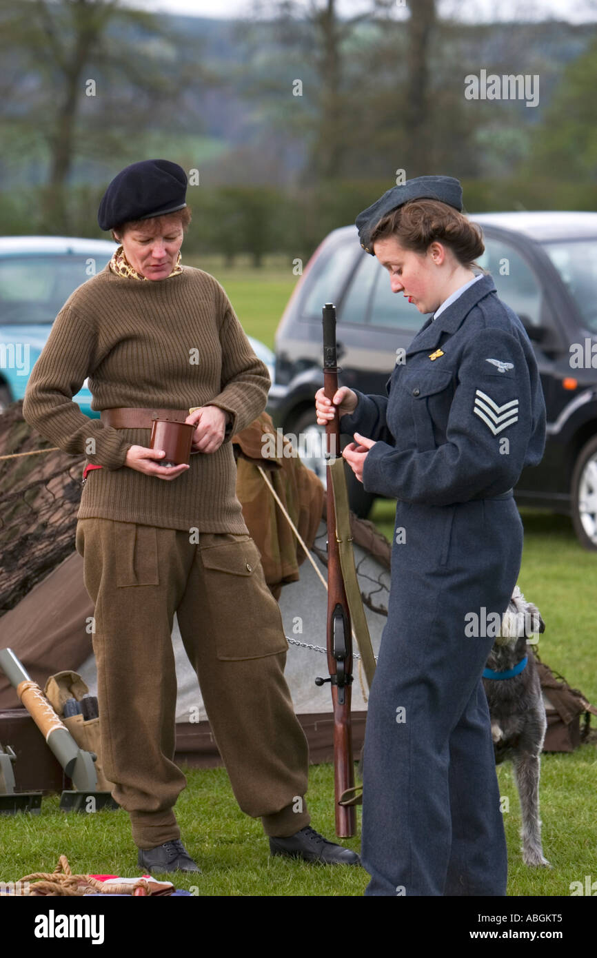 Two female WW2 military reenactors take a break during reenactment ...