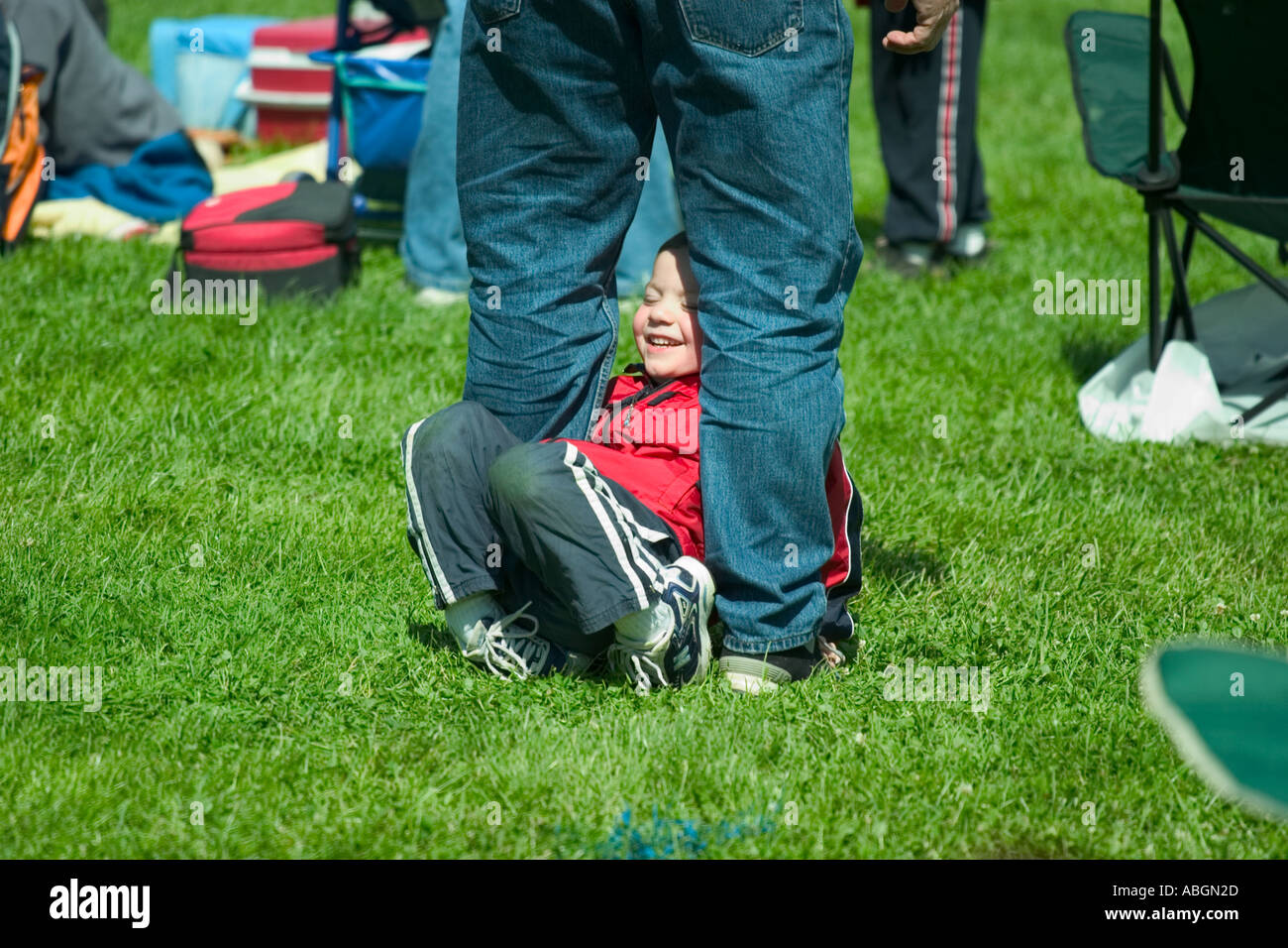 Young boy playfully crawling between the legs of an adult Stock Photo ...