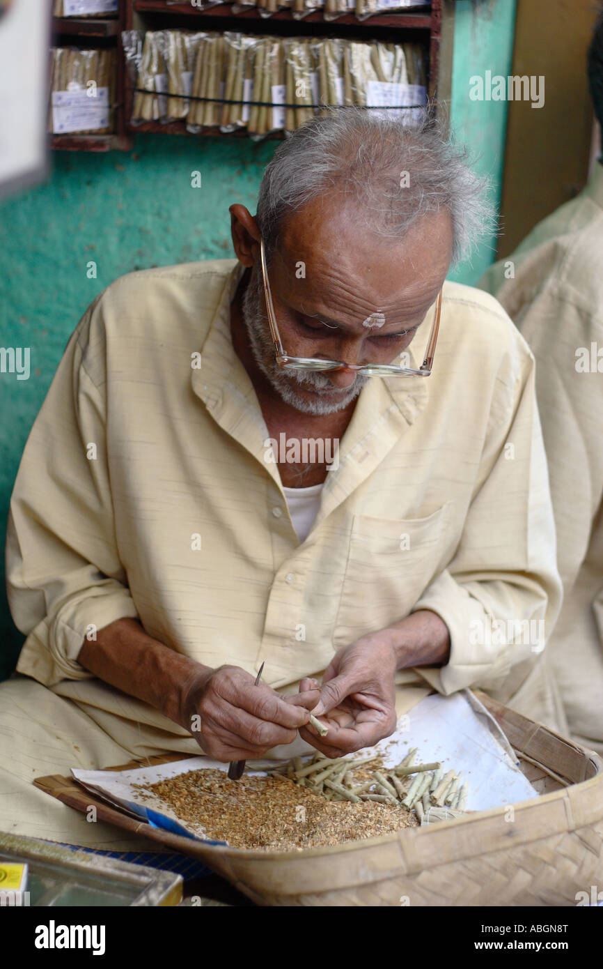 Indian man makes Bidies (hand made cigarettes) in a small alley shop ...