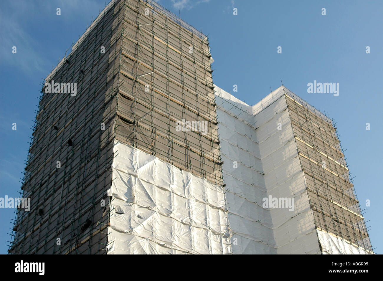 Tower block undergoing building work with scaffold and protective ...