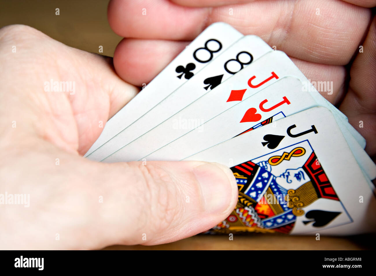 stock photo of a winning full house hand of cards beging protected from ...