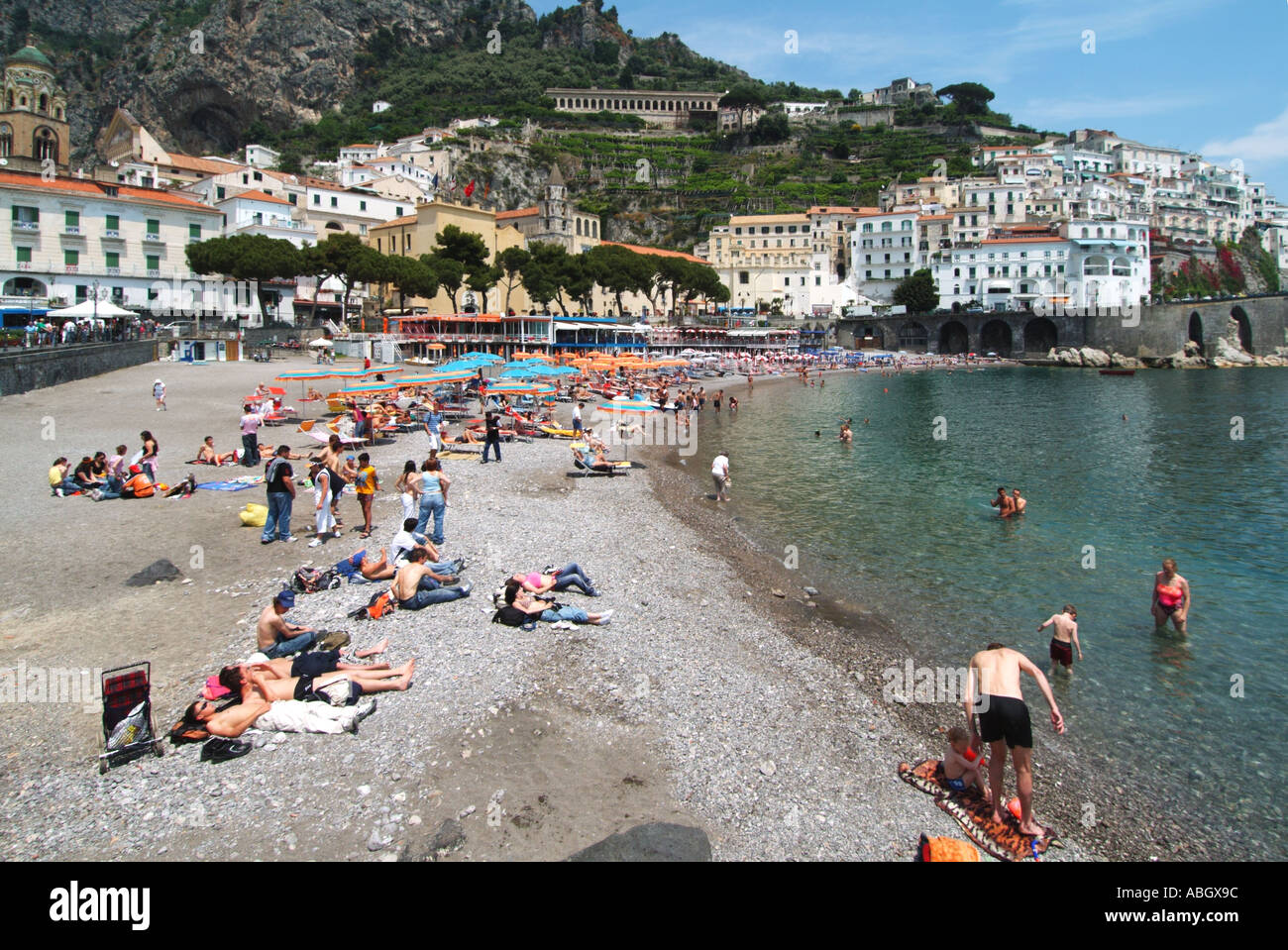 Tourist visitors & locals on Amalfi town seaside beach blue sky views ...