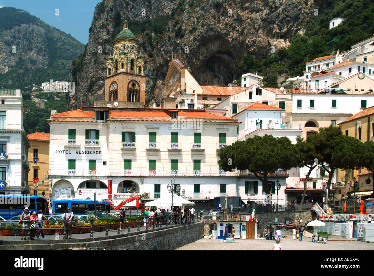 Amalfi town people walking along waterfront promenade adjacent to beach ...