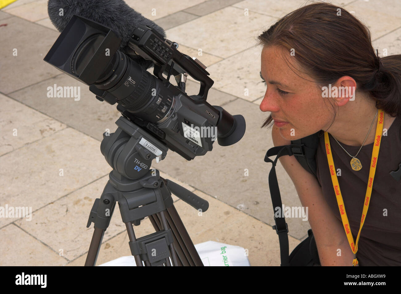 Woman videographer watching camera monitor while filming for BBC ...