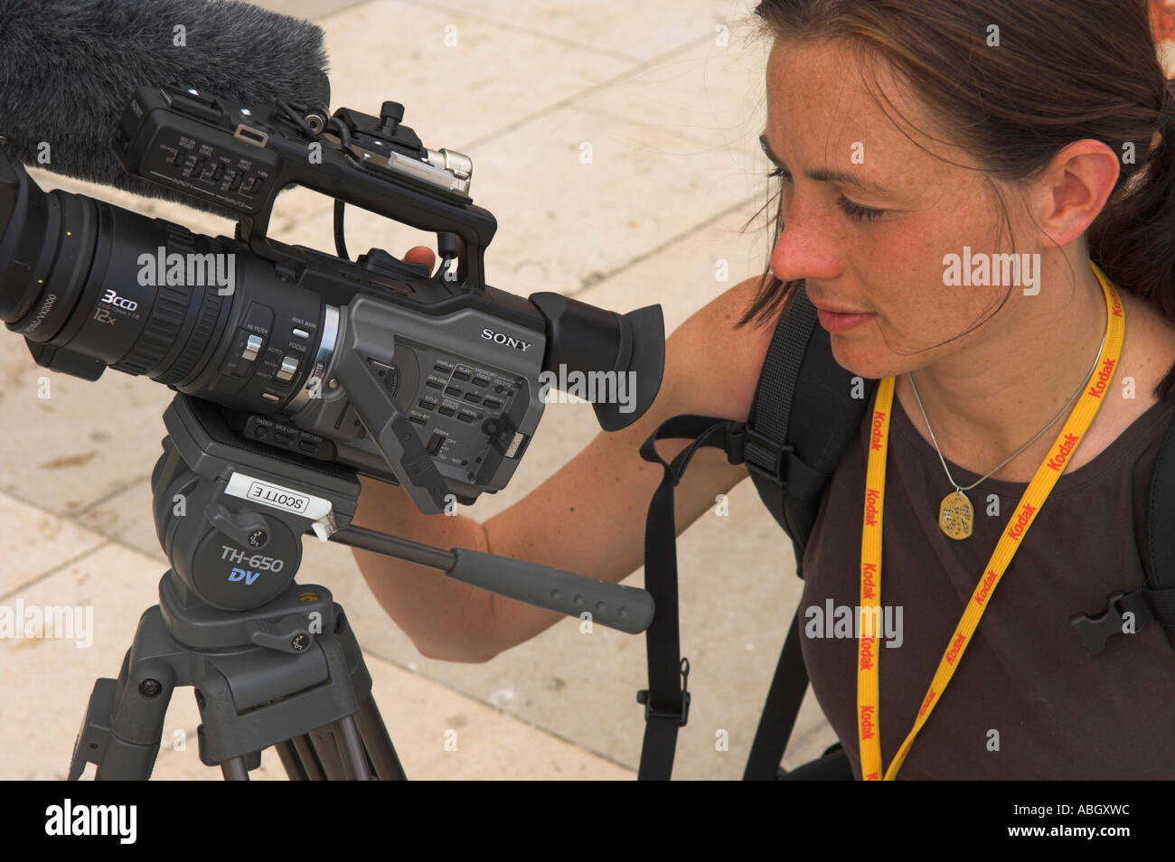 Woman videographer filming for BBC television checking LCD monitor on ...