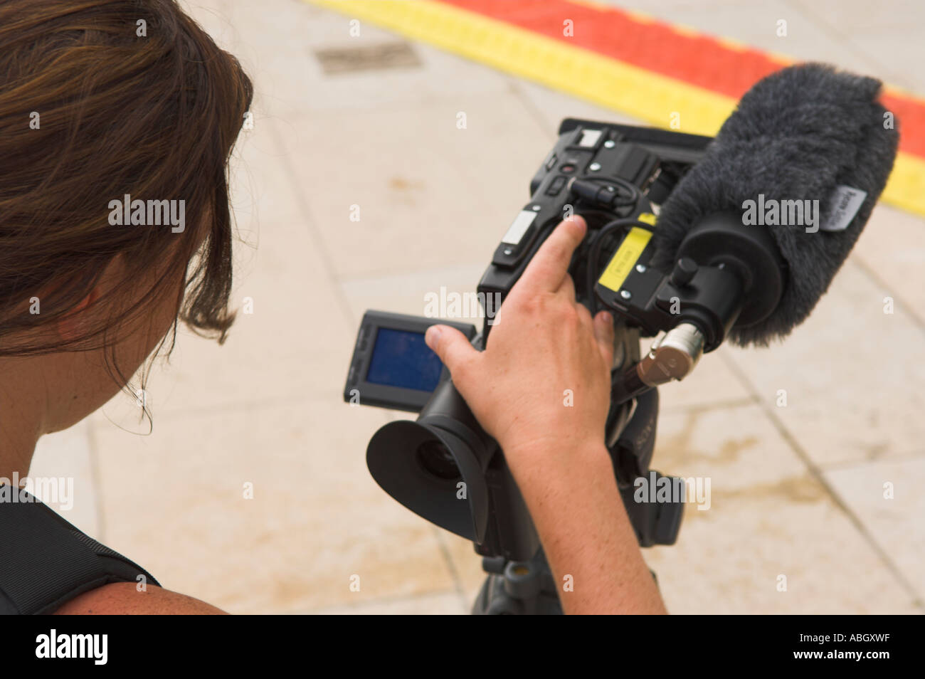 Woman videographer filming for BBC television checking LCD monitor on ...