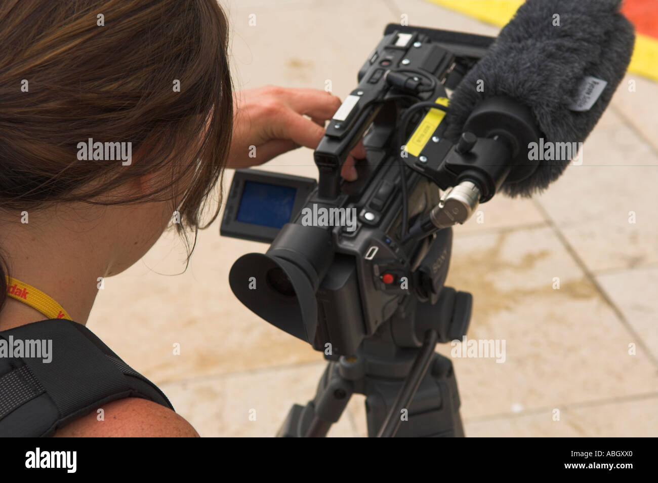 Woman videographer filming for BBC television checking LCD monitor on ...