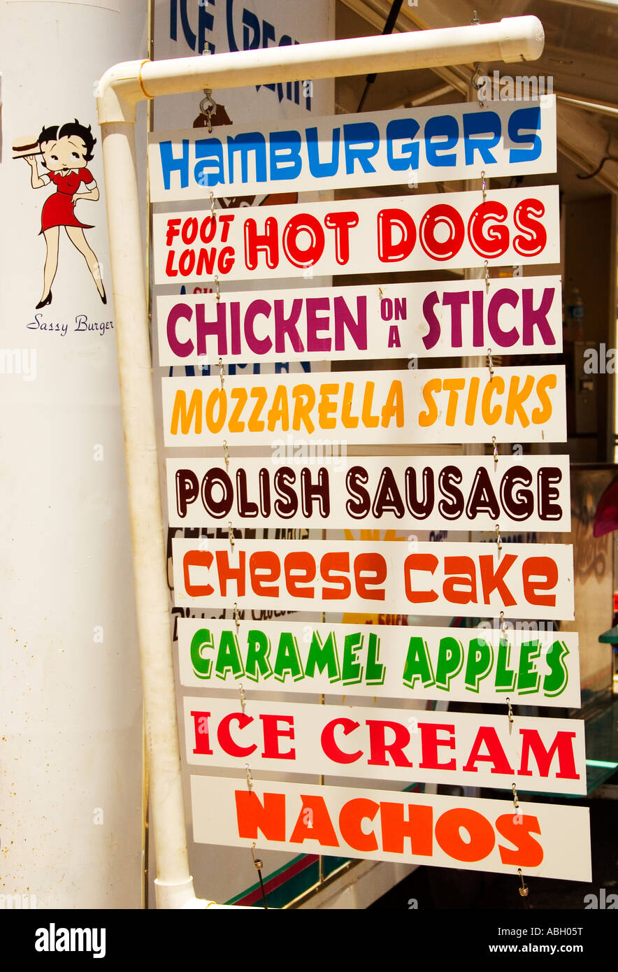 Colorful food vendor signs in front of a food trailer at a summer fair ...