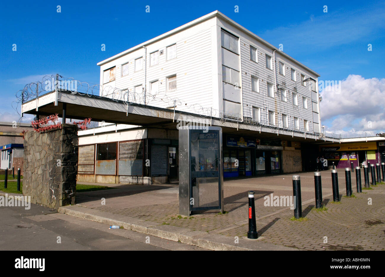 Derelict block of flats boarded up on run down shopping centre with ...