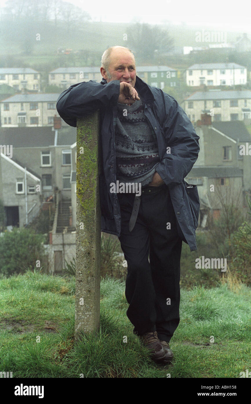 Man leaning on an old fence post with one hand in his trousers watching ...