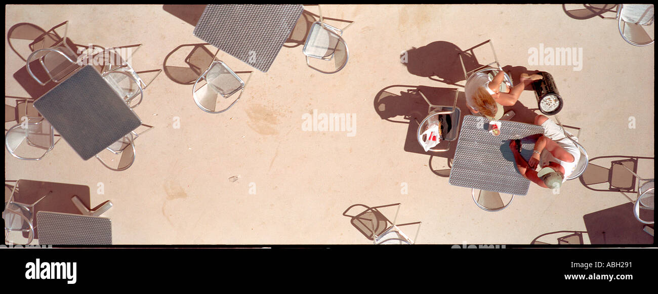 A birds eye view of a tan patio with silver metal tables and chairs ...