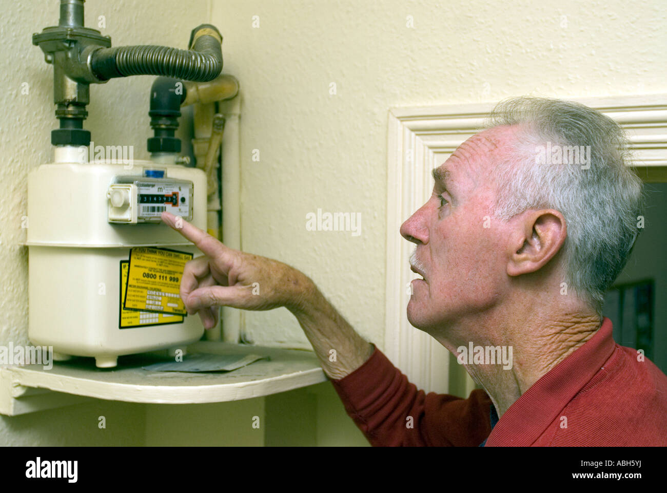 71 year old elderly man reading gas meter at home, London, UK Stock ...