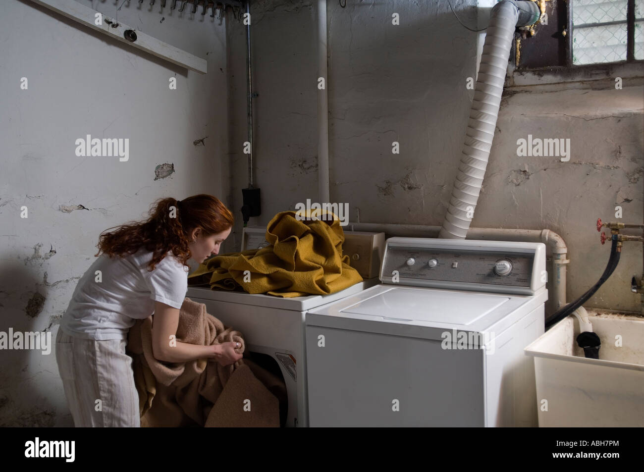 A girl doing her laundry in her basement Stock Photo - Alamy