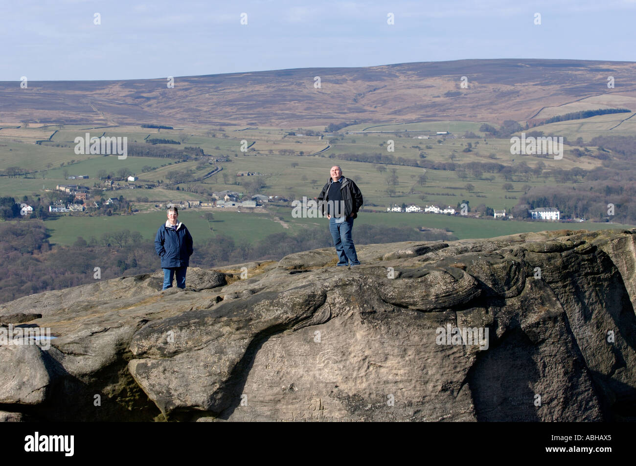 Walkers standing on and looking over the edge of Cow and Calf Rocks ...