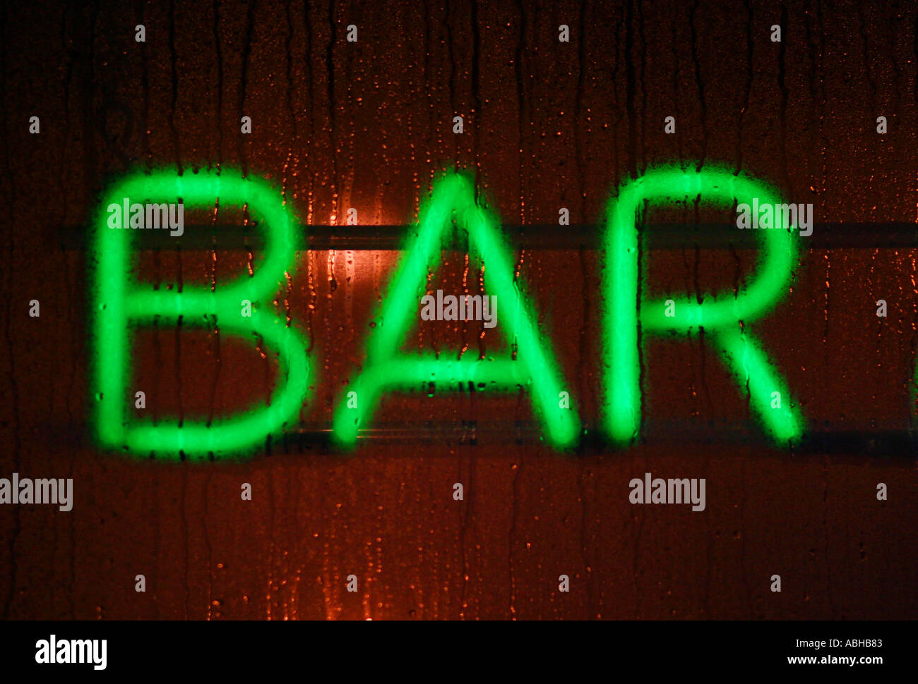 noen sign saying BAR green lettering night time rain streaked glass ...
