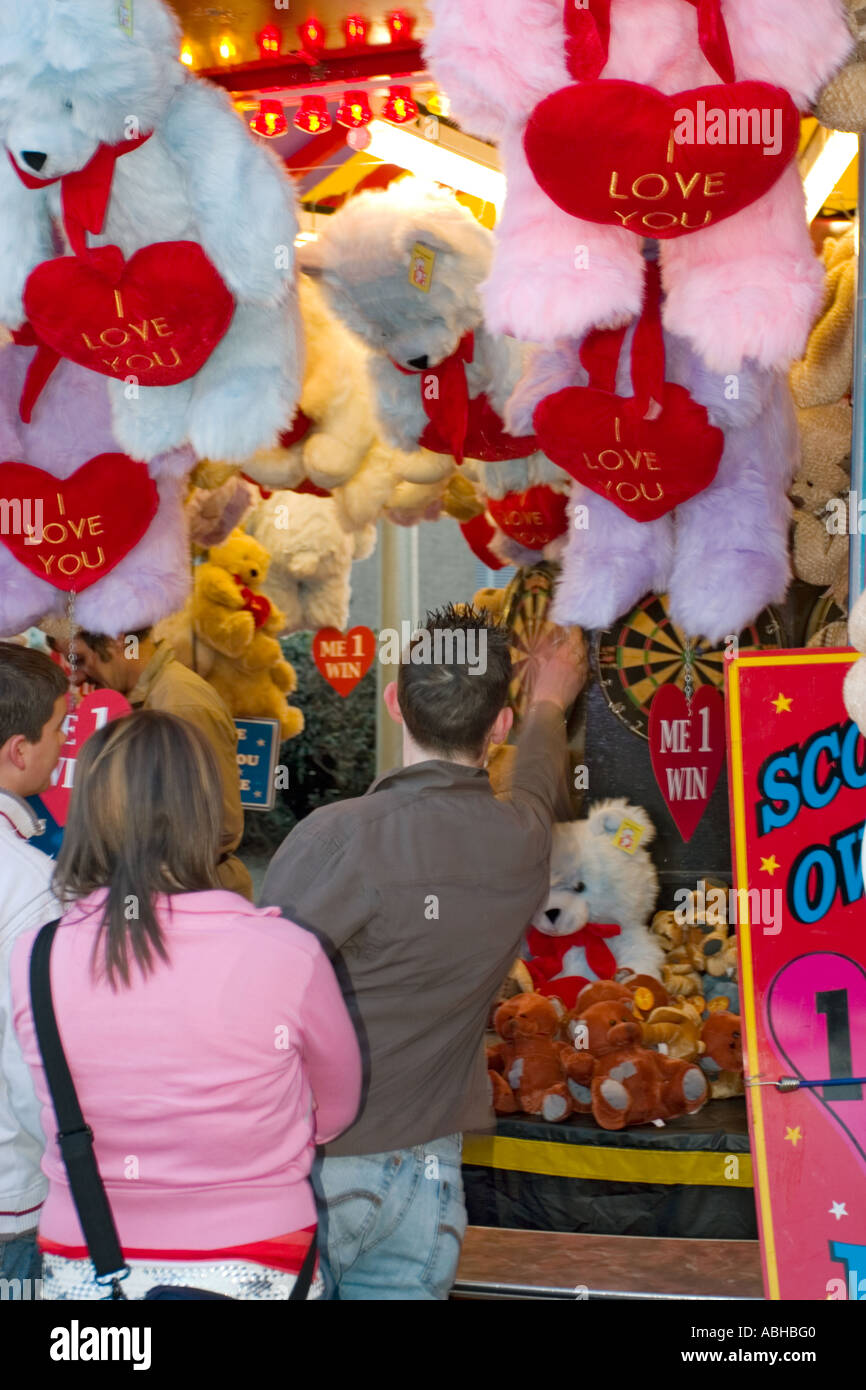 Man playing darts game at fairground sideshow Stock Photo - Alamy