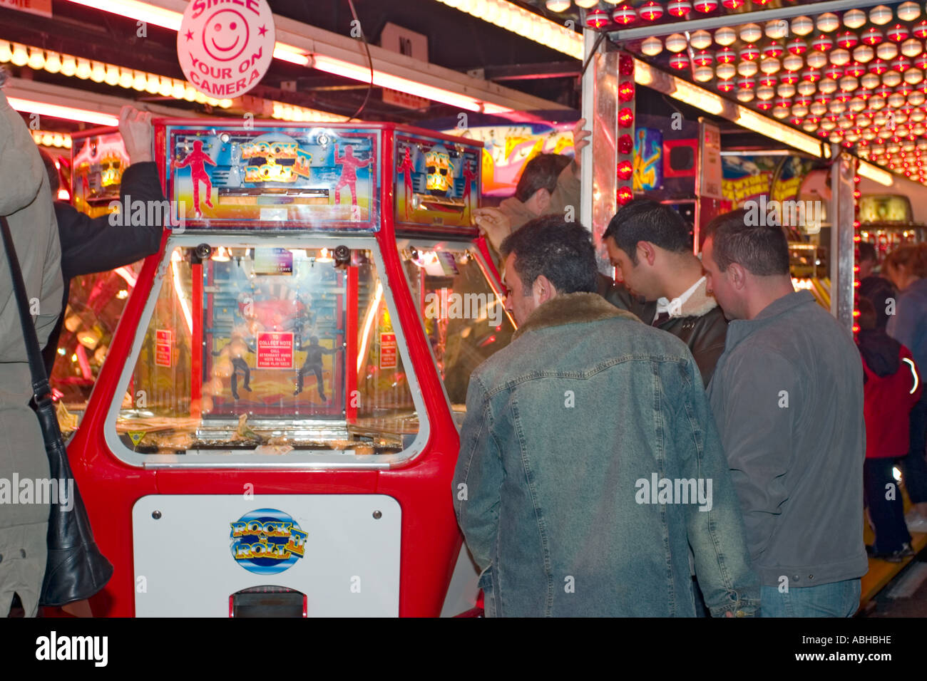 Group of young men playing sideshow games at fairground Stock Photo - Alamy