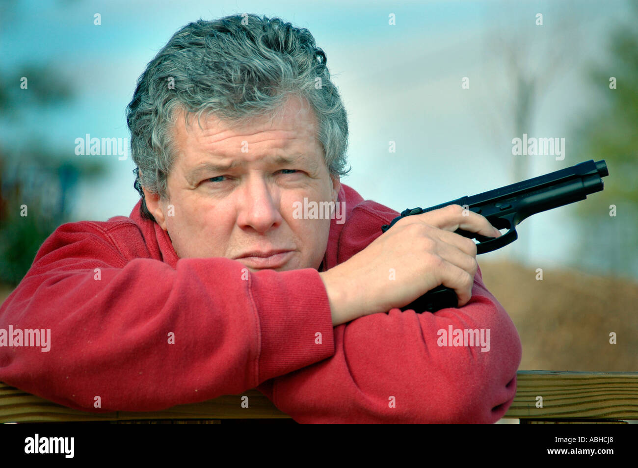 Man with a pistol thinking about Stock Photo - Alamy