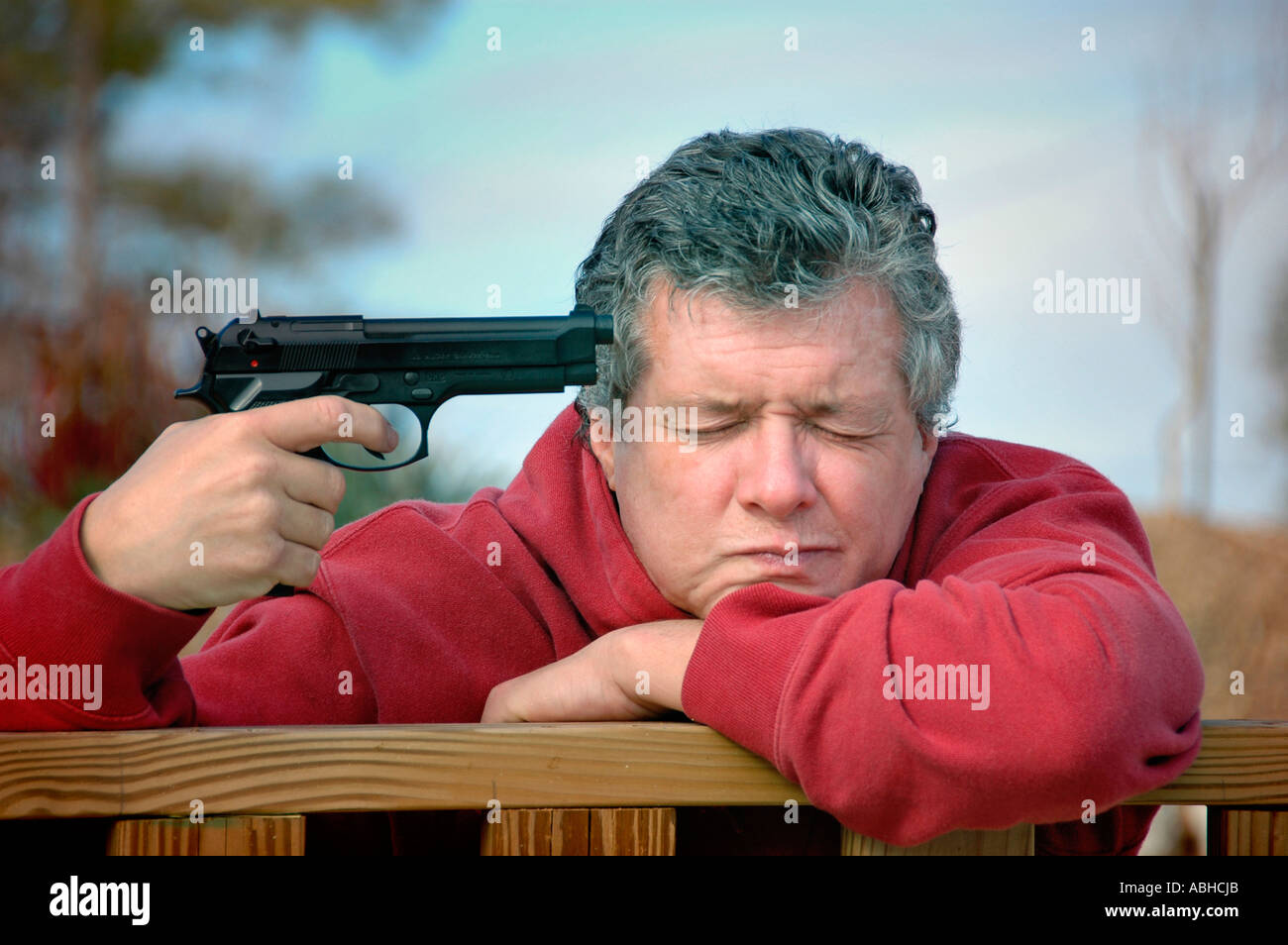 Man with a pistol thinking about Stock Photo - Alamy