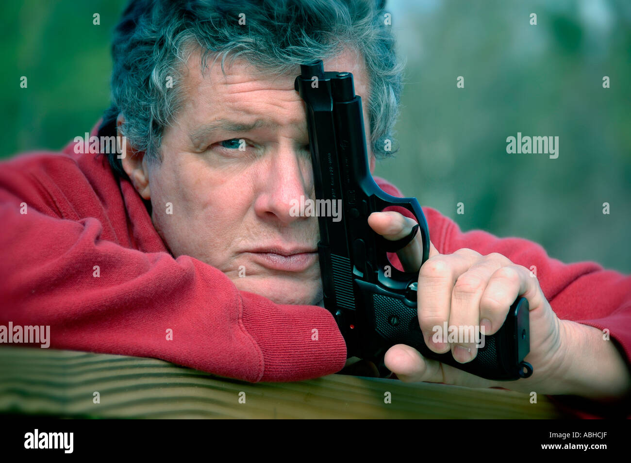Man with a pistol thinking about Stock Photo - Alamy