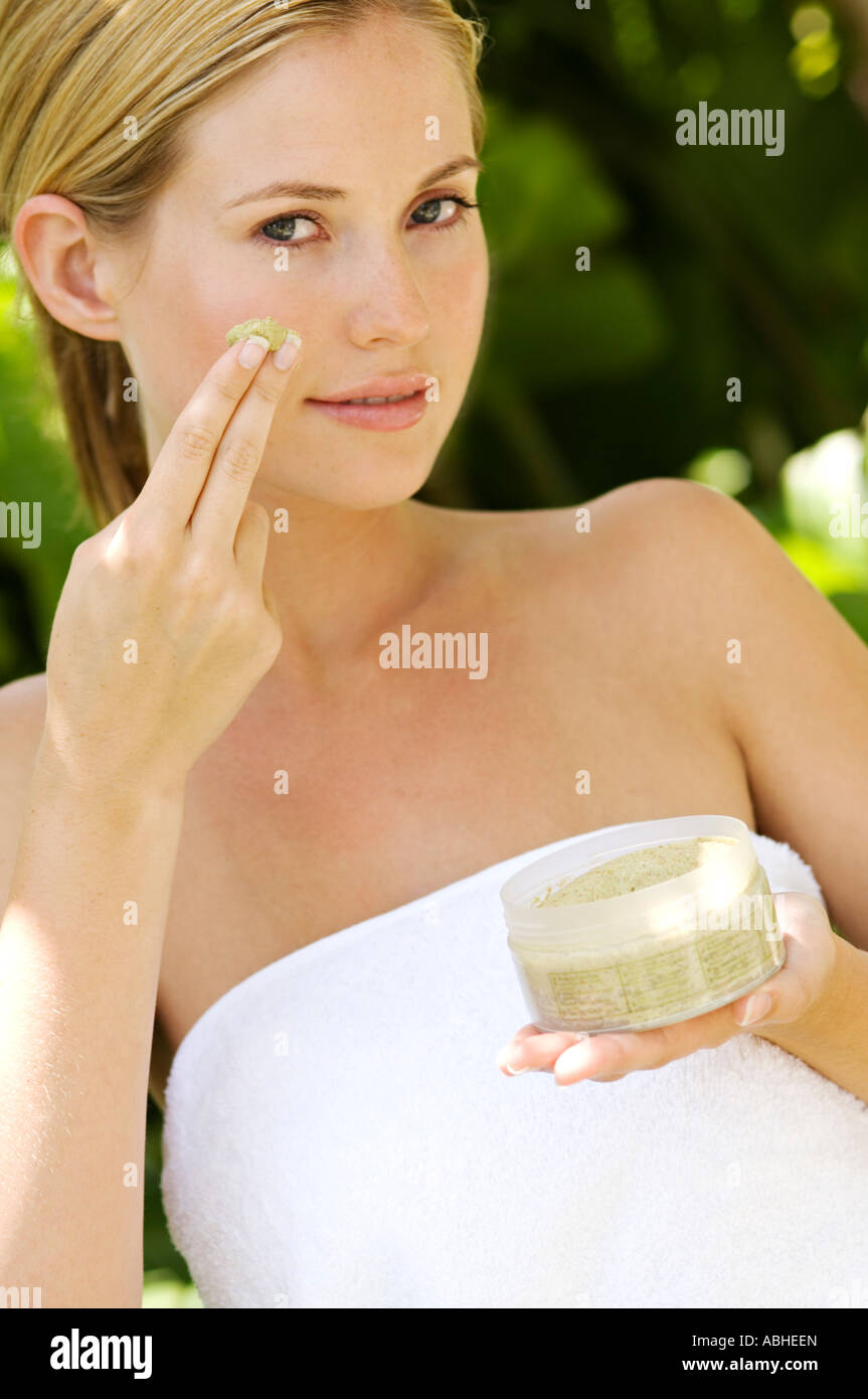 Young woman applying face scrub cream on her face, outdoors Stock Photo ...