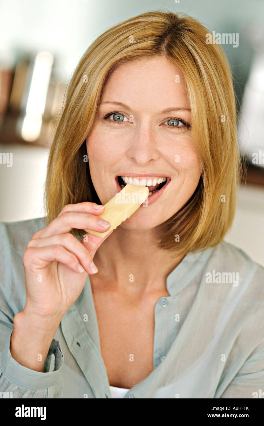 Portrait of a woman eating cheese Stock Photo - Alamy