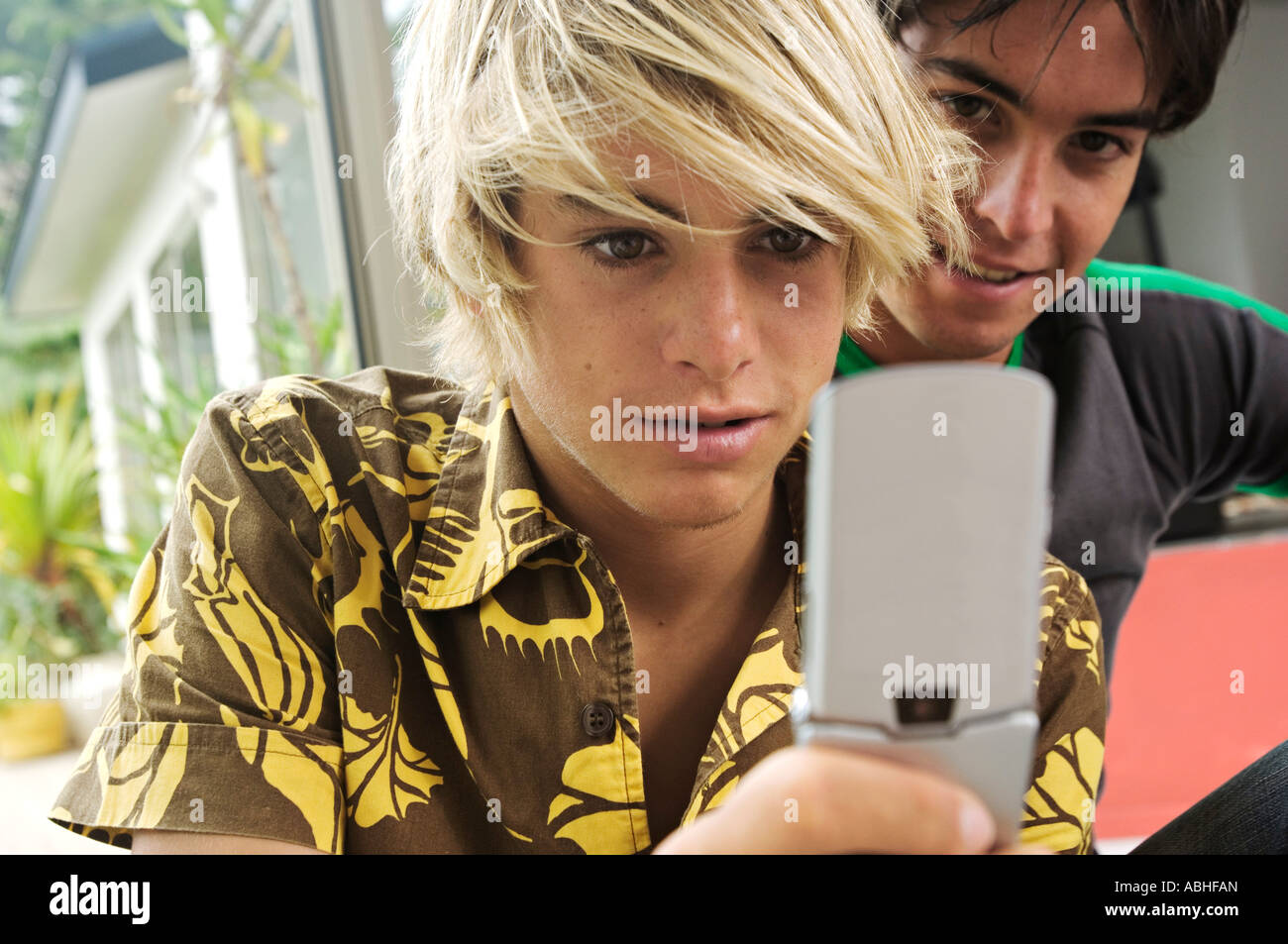 2 teenage boys using mobile phone Stock Photo - Alamy
