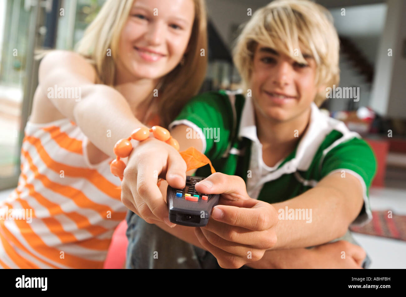 Teenage boy and girl using remote control Stock Photo - Alamy