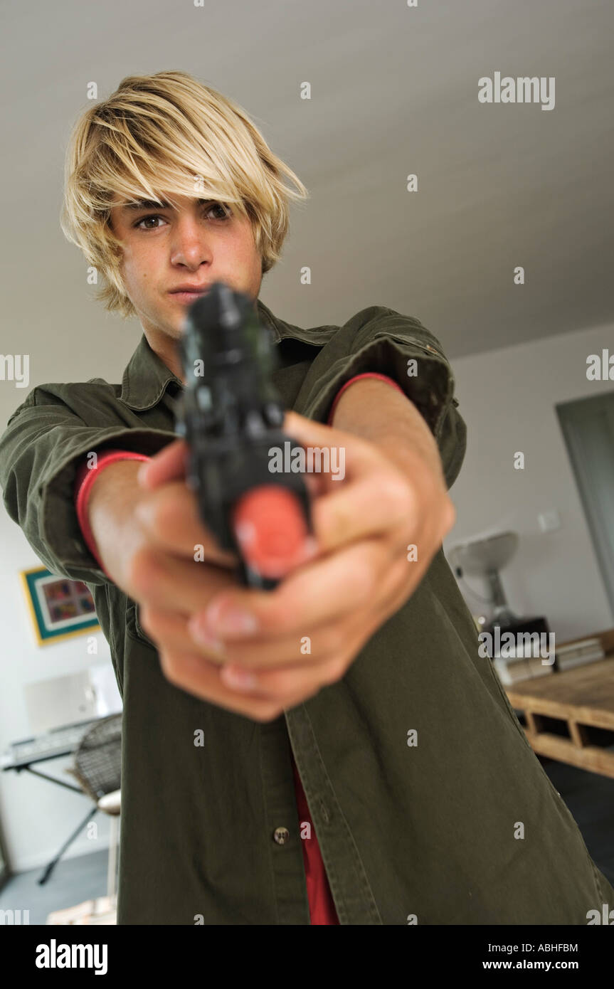 Teenage boy aiming handgun Stock Photo - Alamy