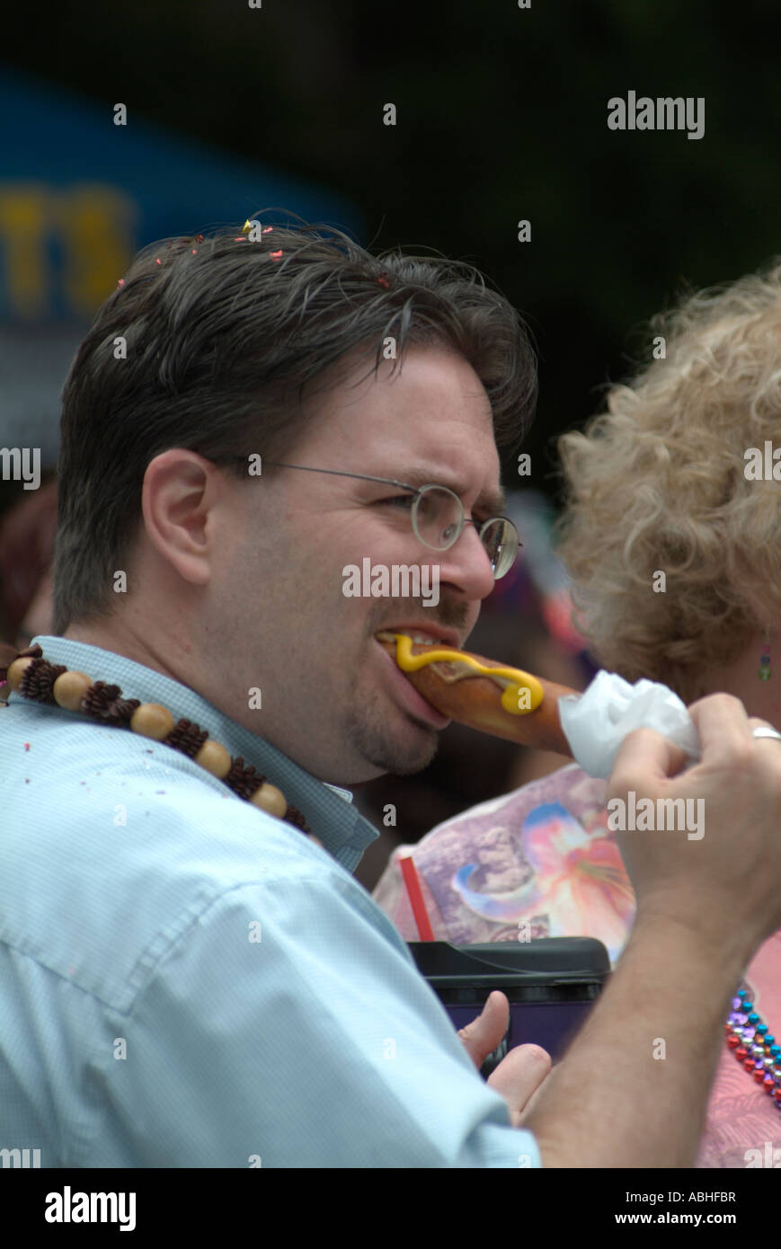Man eating a sausage with mustard in San Antonio Stock Photo - Alamy