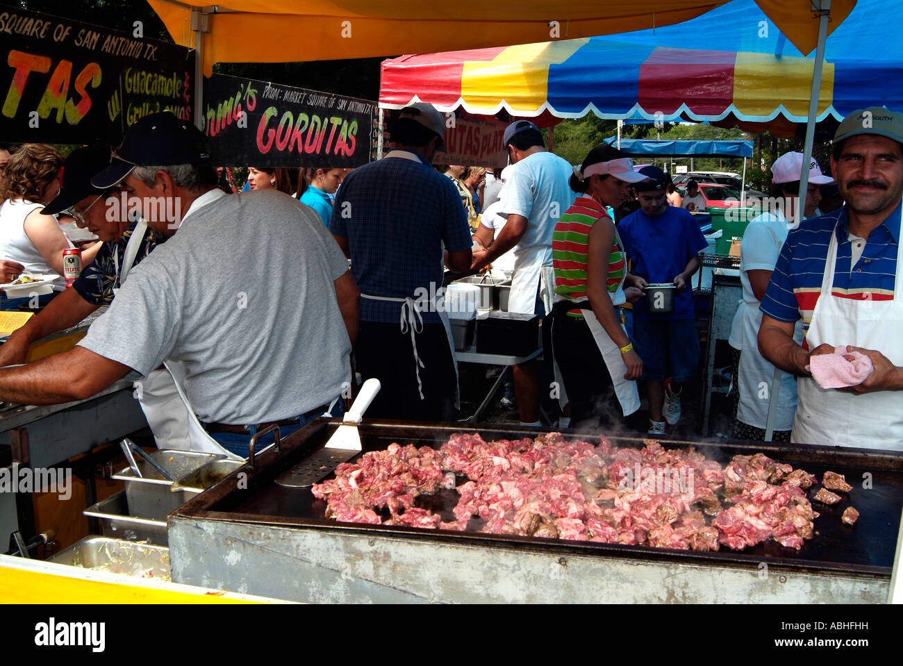 Cooks preparing meat in a booth during a feast in San Antonio Stock ...