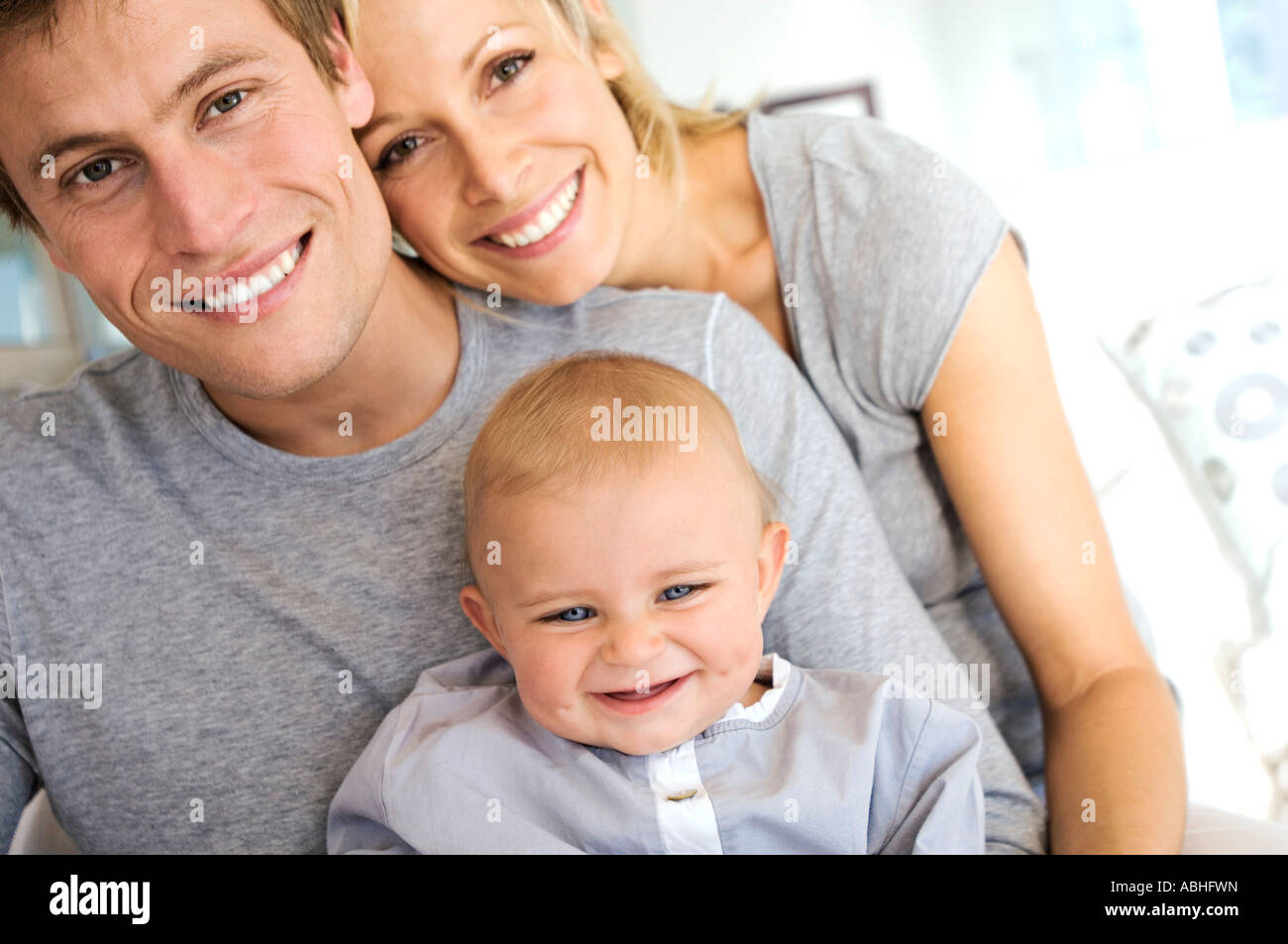 Portrait parents and baby smiling, indoors Stock Photo - Alamy
