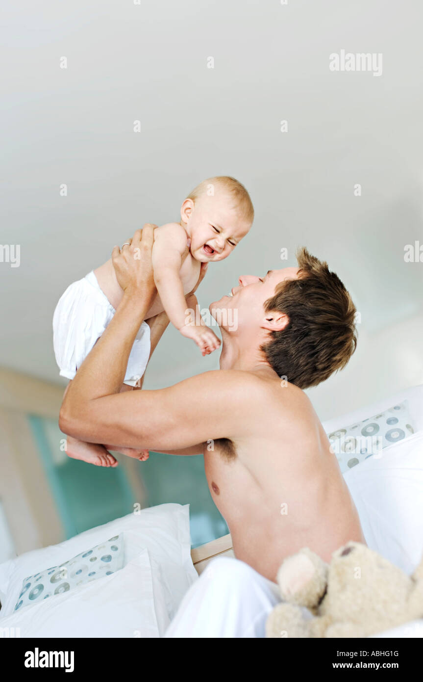 Father lifting his baby, crying, indoors Stock Photo - Alamy