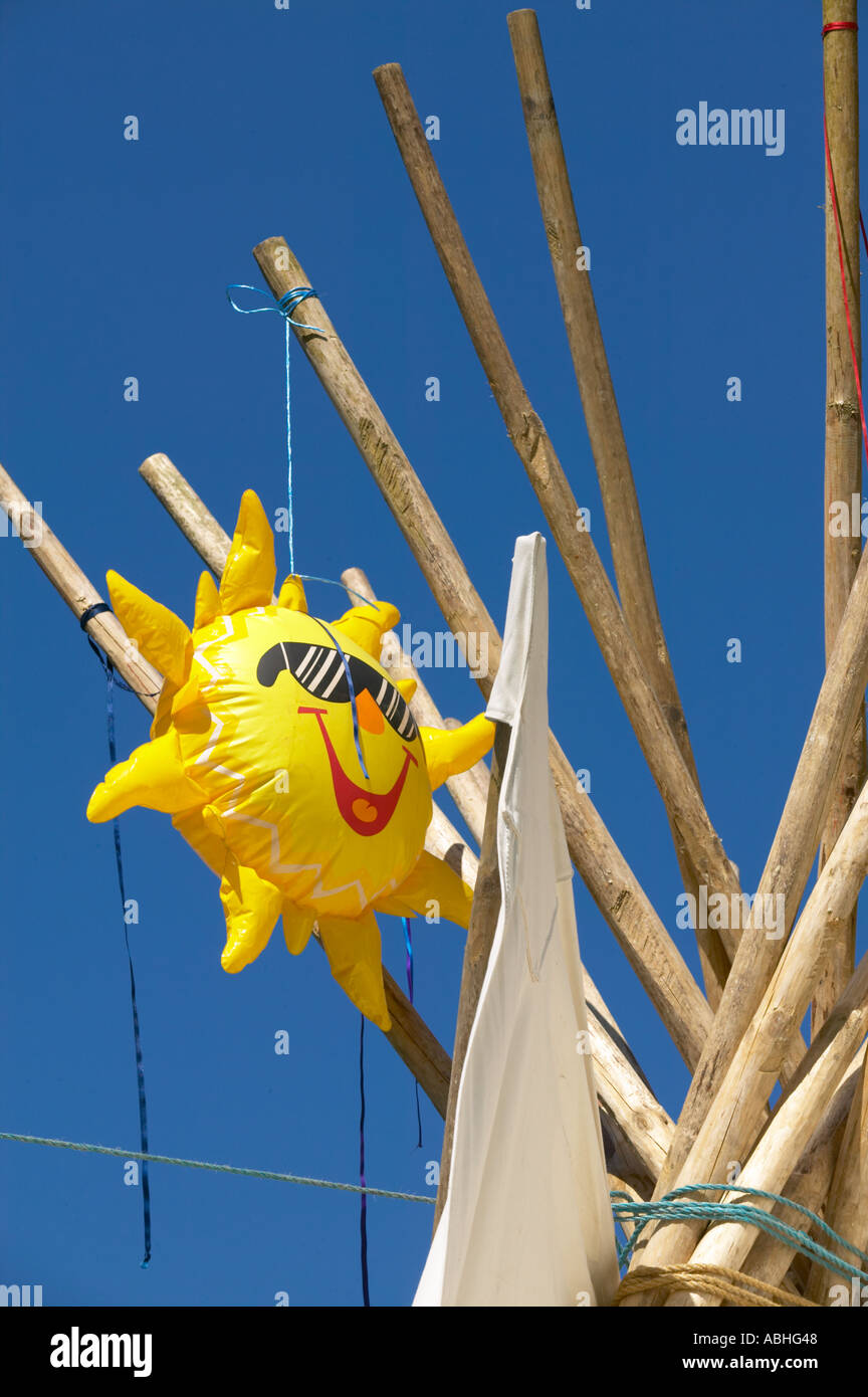 A yellow sun balloon flying from a traditional North American tipi ...
