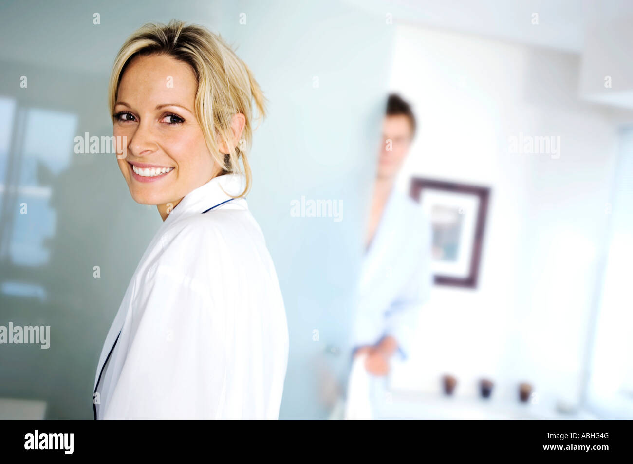 Portrait of a young woman smiling, looking at the camera, man in ...