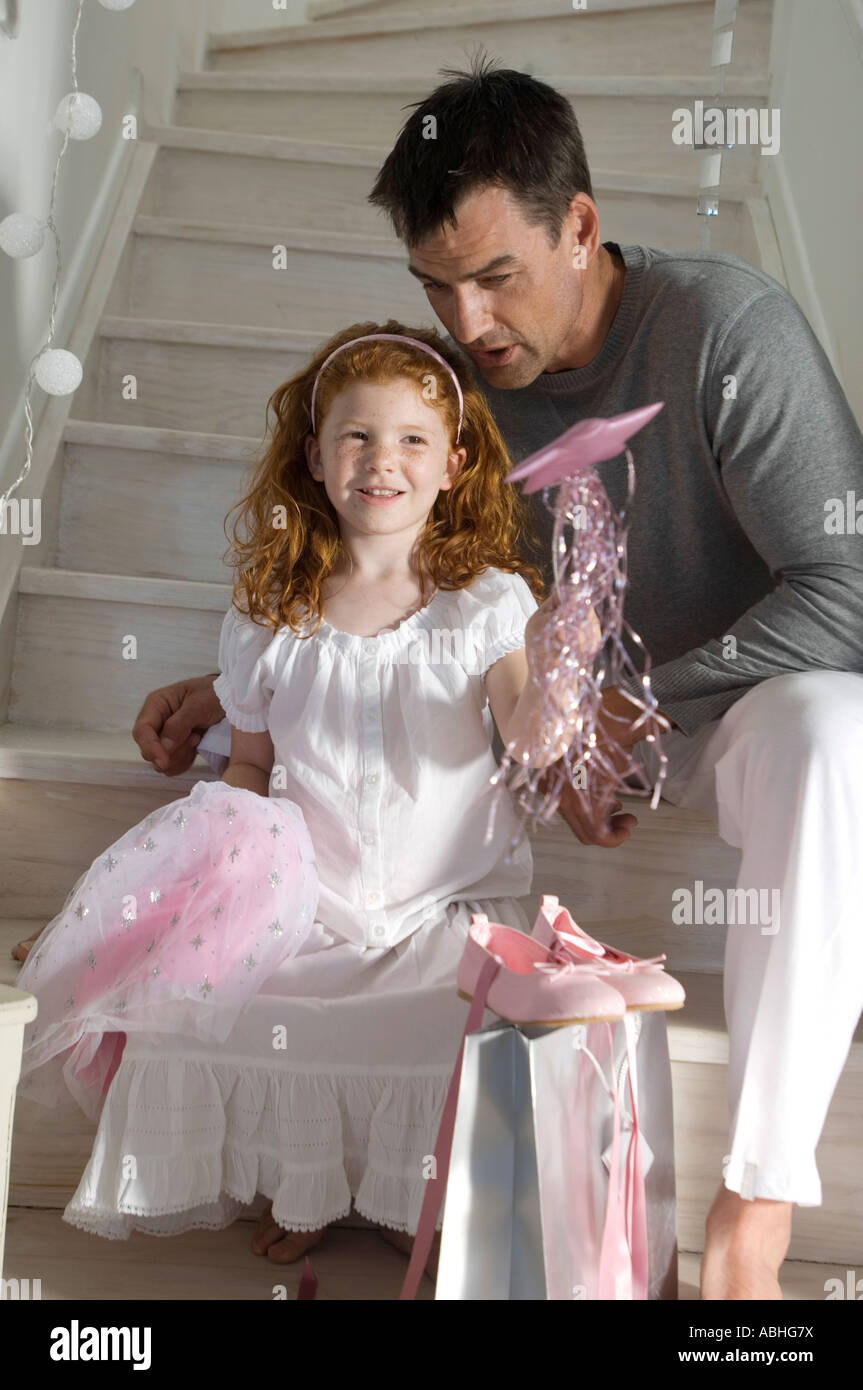 Father and daughter with Christmas presents, girl holding a princess ...