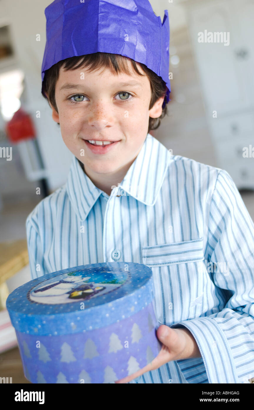 Christmas day, portrait of a little boy opening his present in a blue ...