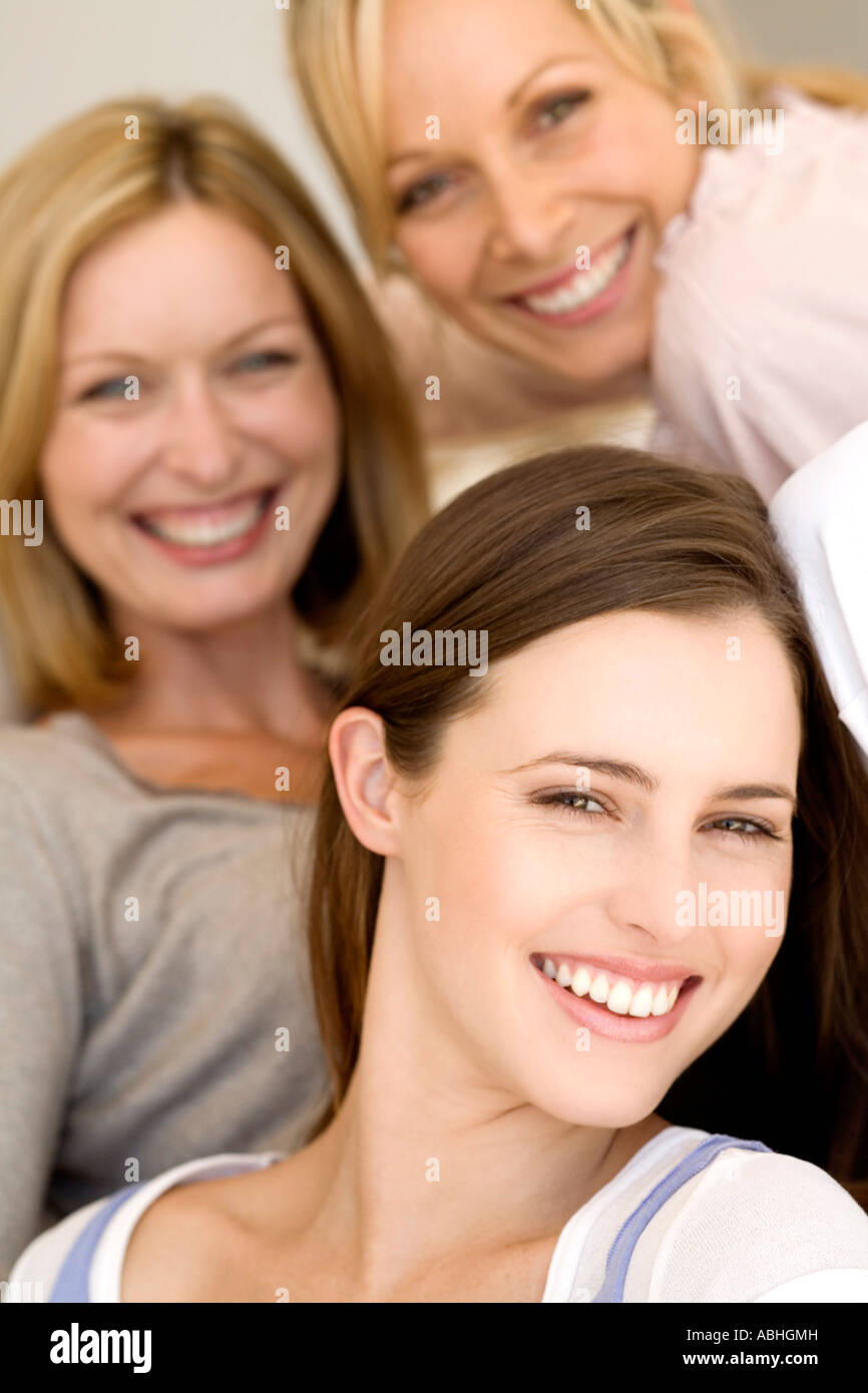 Three women smiling for the camera, indoors Stock Photo - Alamy