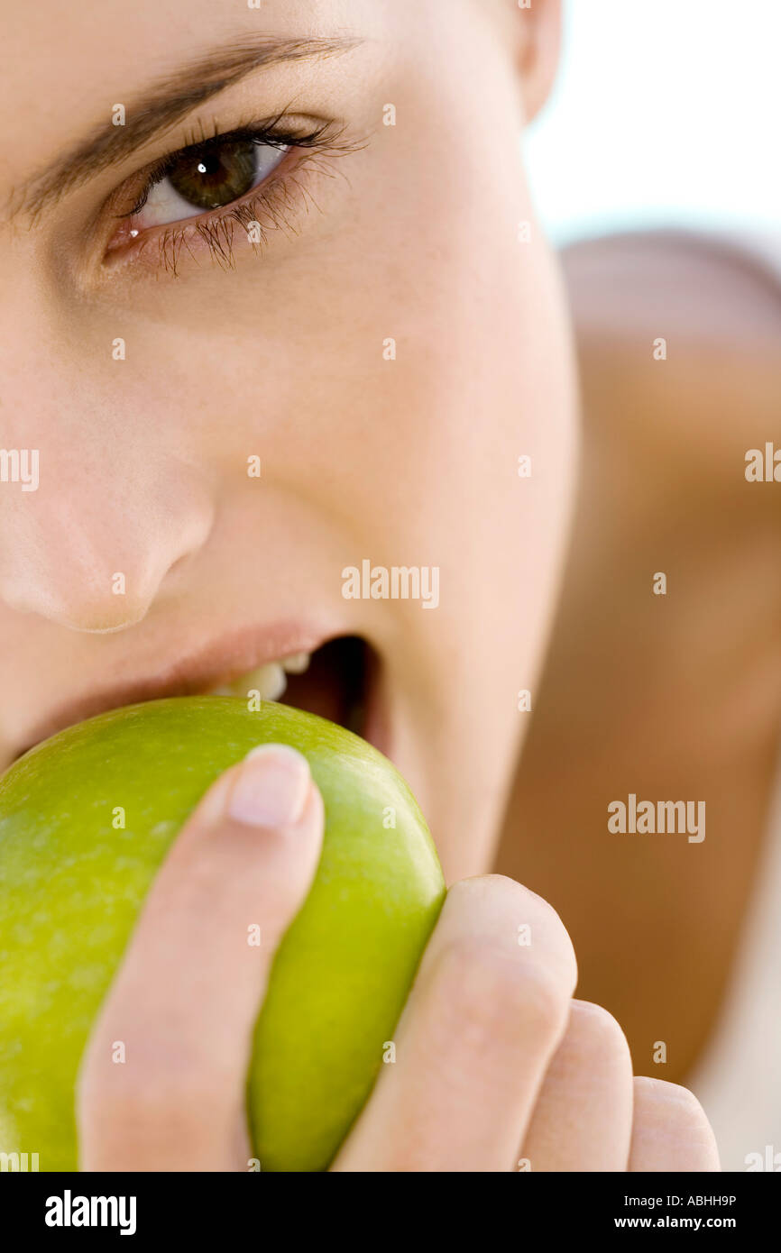 Portrait of a young woman eating an apple, indoors Stock Photo - Alamy